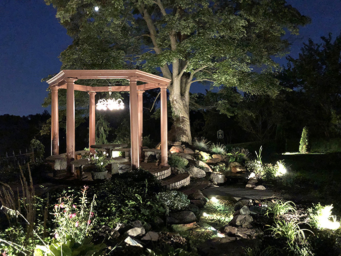 Nighttime Magic: The illuminated gazebo transforms into a fairytale setting after dark, casting enchanting light across the garden pond.