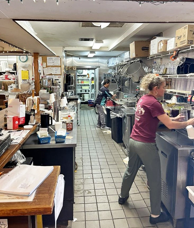 The engine room of happiness, where skilled hands transform ordinary ingredients into extraordinary meals that keep folks coming back for decades.