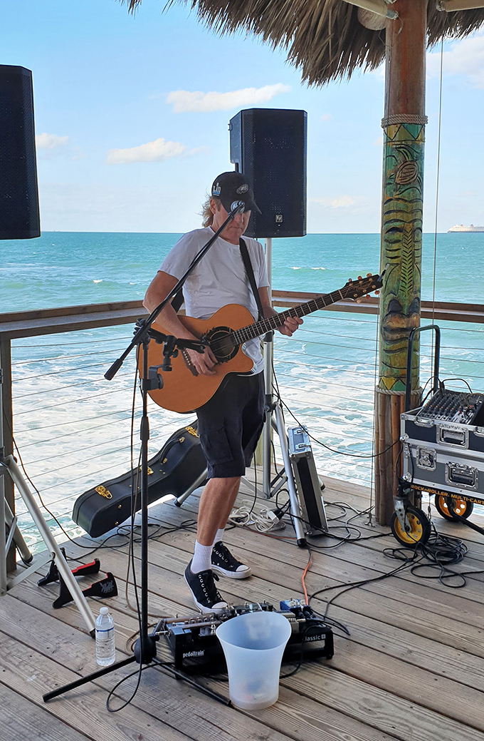 Live music drifts across the deck as waves provide percussion below &ndash; this guitarist turning ordinary afternoons into memories that last long after sunburn fades.