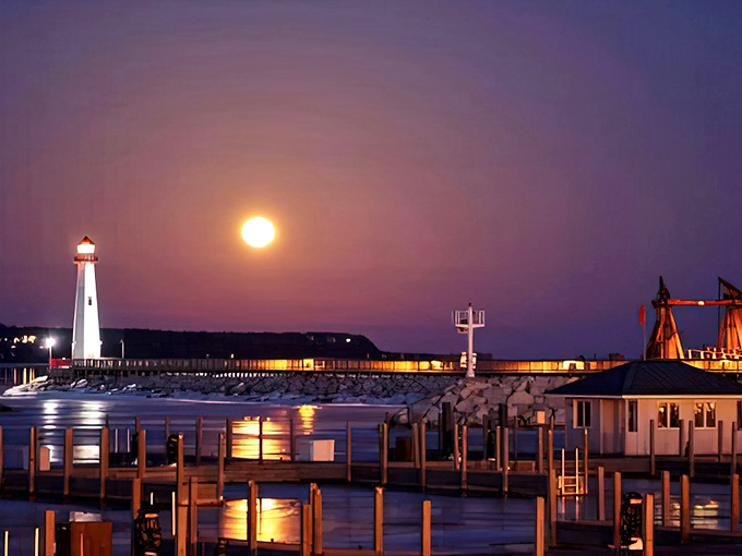 Under a full moon, the lighthouse transforms into a magical beacon, while the harbor lights create their own constellation on water.