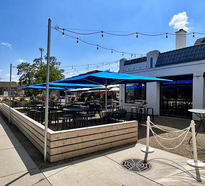 The outdoor patio with its blue umbrellas offers an urban oasis where summer breezes complement spicy salsas perfectly.