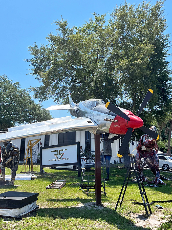 A full-sized metal airplane sculpture prepares for takeoff from the lawn – the Wright brothers would be impressed by this scrap metal flyer.