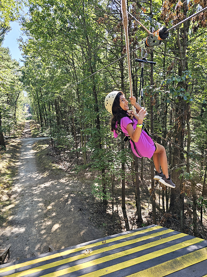A young adventurer beams with pride, discovering courage and joy while navigating the ropes among the trees.
