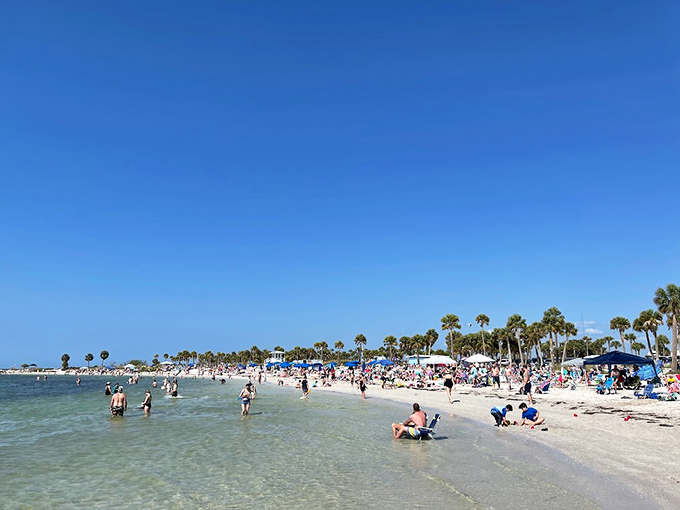 Sun-worshippers dot the shoreline, each finding their perfect spot on this uncrowded stretch of coastal heaven.