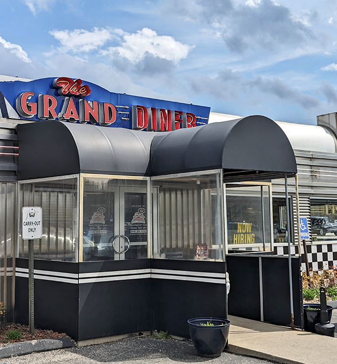 The entrance beckons with its curved awning and checkerboard accents, a portal to a time when diners were the heart of American social life.