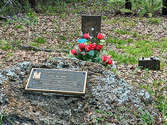 Artificial flowers bring splashes of color to the grave site, proof that someone still remembers the pioneers who rest here.
