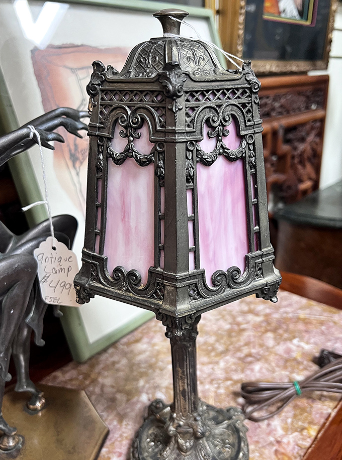 This delicate metal lamp with pink glass panels transforms ordinary illumination into a rosy-hued magical experience from another era.