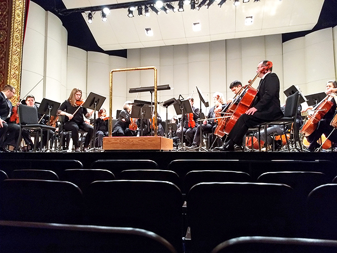 Musicians prepare for performance in the intimate setting where every note will resonate through a space designed for acoustic perfection.