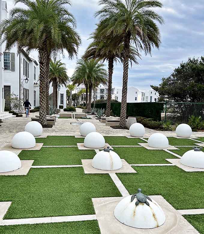 Palm trees create natural columns in this outdoor gathering space, where white domes emerge like sculptural eggs from the manicured lawn.