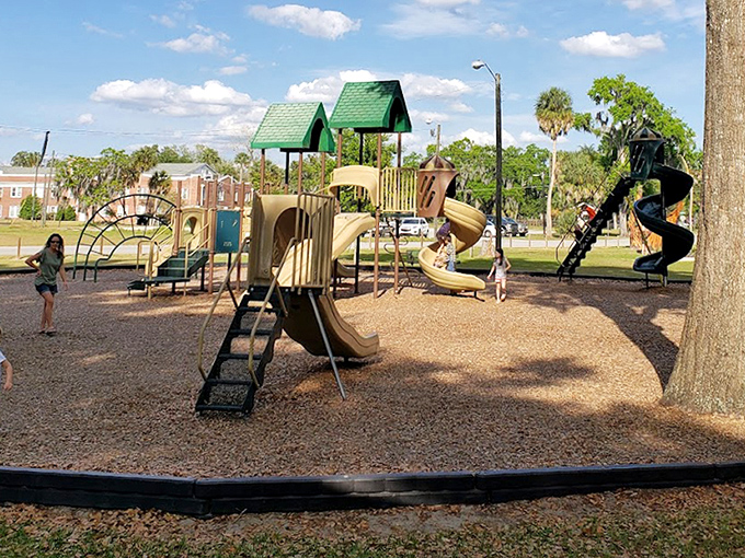 The playground equipment promises adventures for younger visitors, perfectly positioned for parents to watch while enjoying the sculptures.