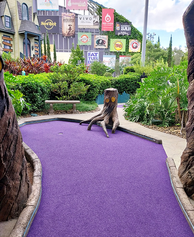 Purple pathways wind between carefully manicured hedges, creating a surreal landscape that feels plucked from a 1950s sci-fi film.