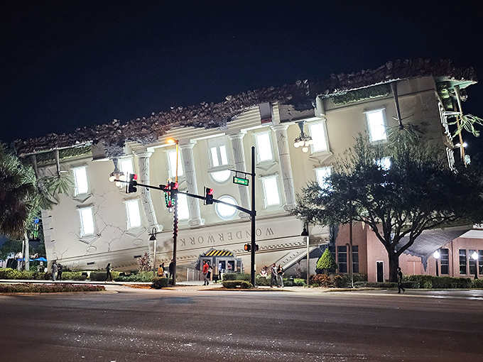 At night, the illuminated upside-down building glows like a beacon for the curious, the confused, and those who appreciate architectural rebellion.