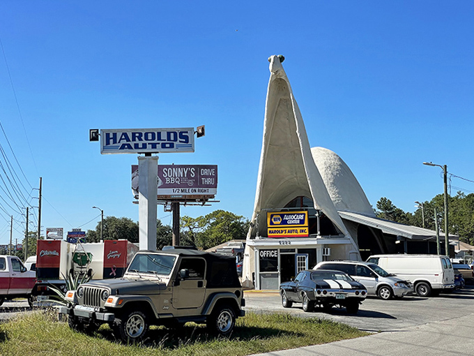 The parking area buzzes with activity, as customers come not just for repairs but for the joy of saying, "My mechanic's a dinosaur."