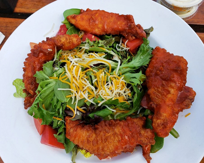 Buffalo chicken salad that somehow makes eating greens feel indulgent &ndash; crispy, spicy chicken atop fresh vegetables for guilt-free pleasure.