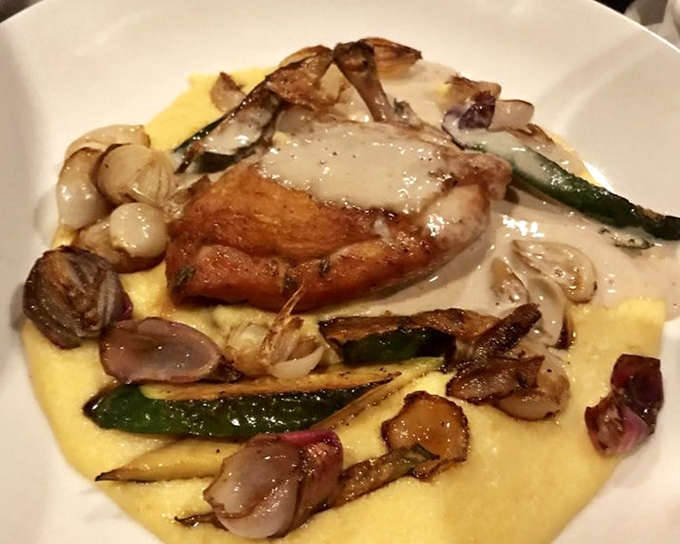 Crispy-skinned chicken nestled on creamy polenta with roasted vegetables&mdash;comfort food that's dressed up but hasn't forgotten where it came from.