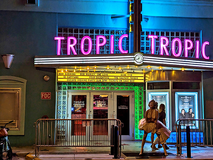 As night falls, the Tropic's neon signage transforms into a glowing invitation to escape into other worlds through the magic of film.