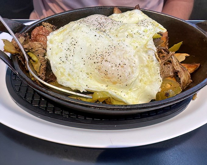 A skillet breakfast hash topped with a perfect egg – the kind of hearty morning fare that makes you cancel lunch plans.