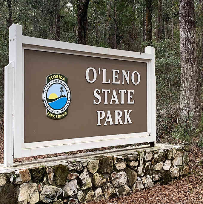 The official welcome sign stands sentinel at the park entrance, a humble introduction to the natural wonders waiting just beyond the gate.