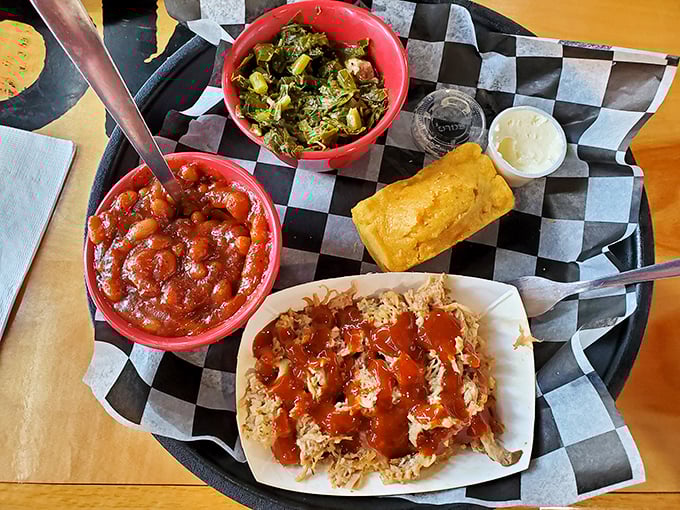 Tender strands of smoky pork glory topped with house sauce, alongside baked beans and collard greens. This plate is Southern comfort in its purest form.