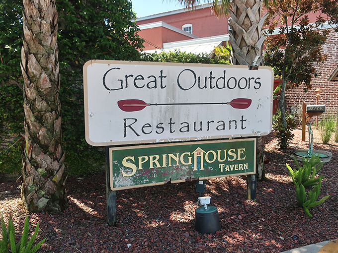 A weathered sign between palm trees announces your arrival at a true local treasure – Great Outdoors Restaurant, where nature meets nurture.