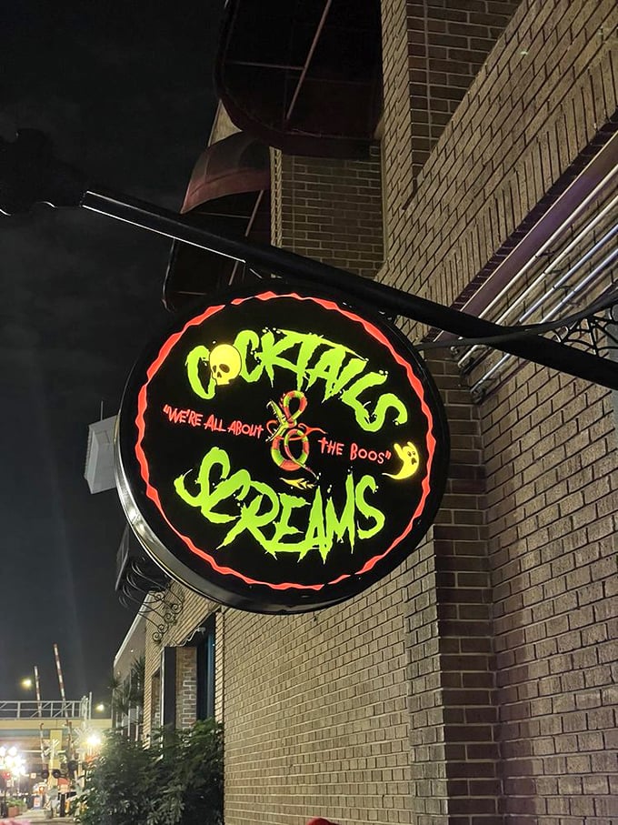 The neon sign glows like a beacon for horror enthusiasts, promising both excellent libations and spine-tingling experiences for those brave enough to step inside.