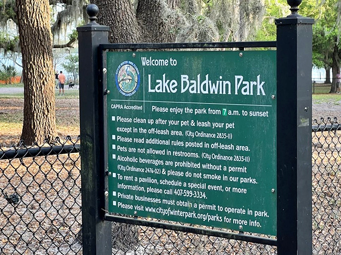 The welcoming sign sets clear expectations – this is a place where dogs and responsible owners come together for lakeside magic.