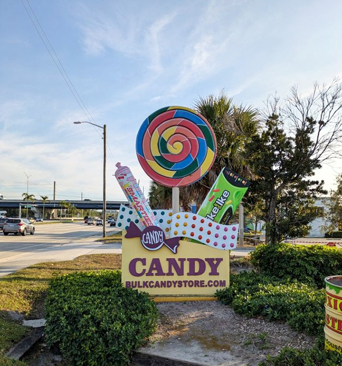 This roadside sign featuring a giant lollipop serves as a beacon for sweet-toothed travelers seeking sugary salvation in Florida.