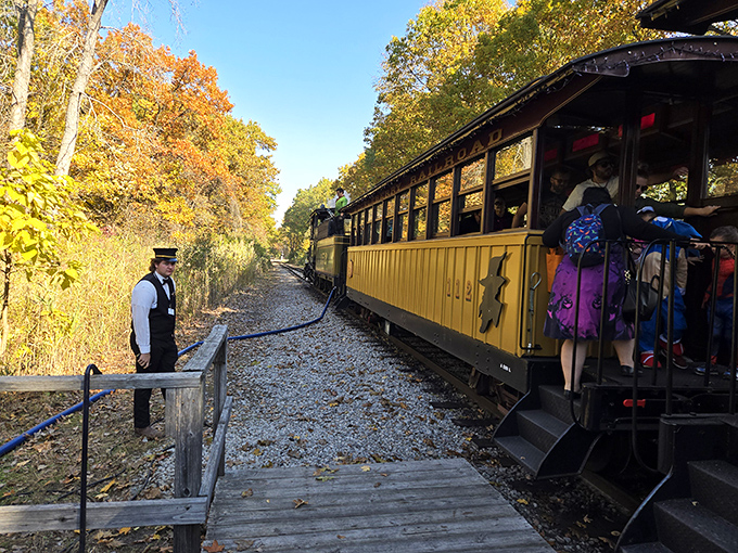 The conductor stands ready for departure, his pocket watch the only technology needed to keep this historical journey right on schedule.