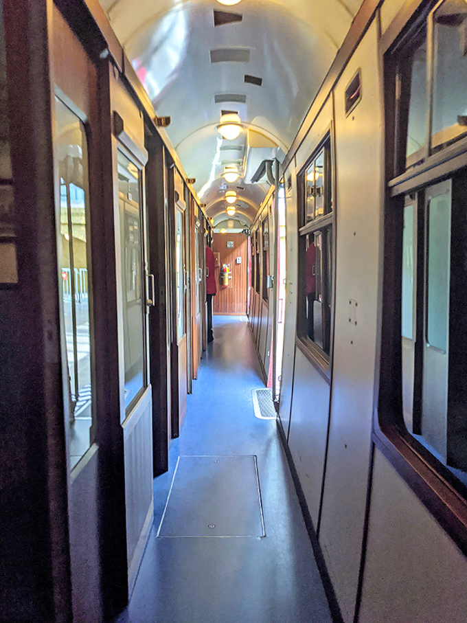 The narrow corridor of the Hogwarts Express carriage perfectly captures the intimate, slightly cramped charm of British rail travel.
