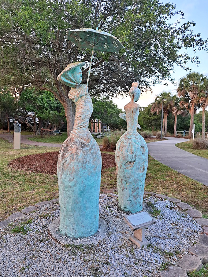 Twin figures in turquoise patina stand like elegant sentinels &ndash; these ladies with their flowing dresses and parasol embody timeless Florida grace.