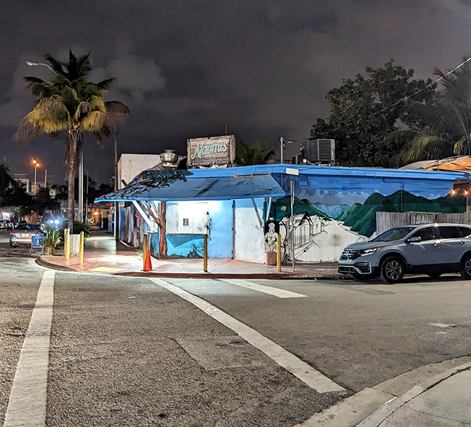 As darkness falls, the blue-painted building glows like a beacon, guiding hungry souls to Caribbean comfort when Miami's glitz grows tiresome.