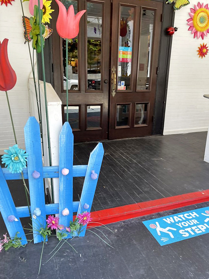 A cheerful blue picket fence and colorful flowers welcome candy seekers to this sugar-filled paradise. The journey begins here!