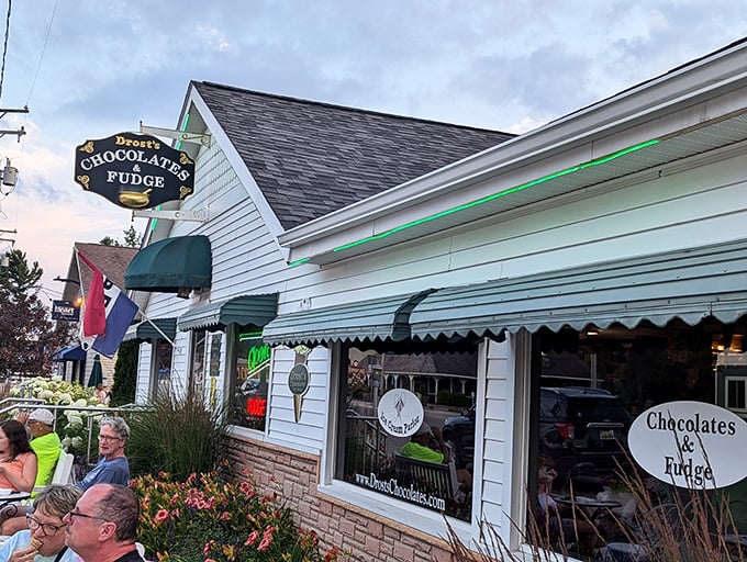 The illuminated Drost's sign glows against the twilight sky, guiding chocolate lovers home like a sweet North Star.