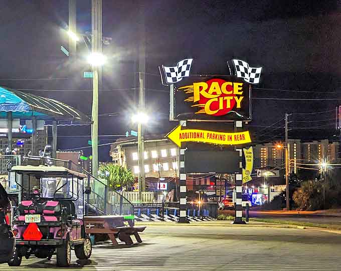 The Race City sign glows against the night sky like a neon lighthouse guiding fun-seekers to shore.