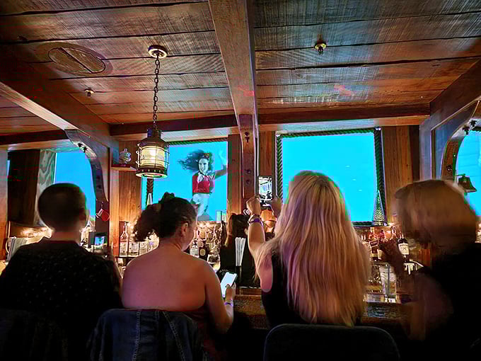 The Wreck Bar's wooden ceiling and nautical lanterns set the stage for the mermaid show visible through those magical portholes. Shipwreck chic at its finest!