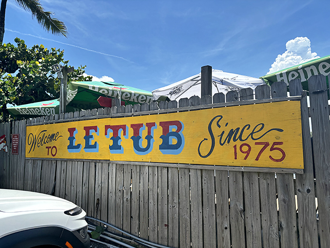 The iconic yellow "Welcome to Le Tub" sign has greeted burger lovers since 1975, promising laid-back waterfront dining.
