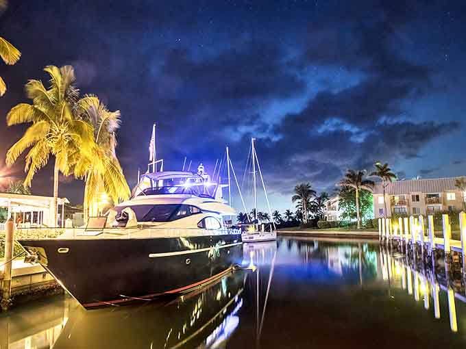 Night falls gently over Captiva's marina, where luxury yachts rest after a day of Gulf adventures, their lights dancing on the still water.