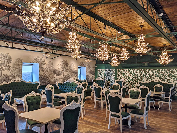 Elegant chandeliers illuminate plush emerald seating, creating a dining space where adults feel pampered while keeping eyes on playing children.