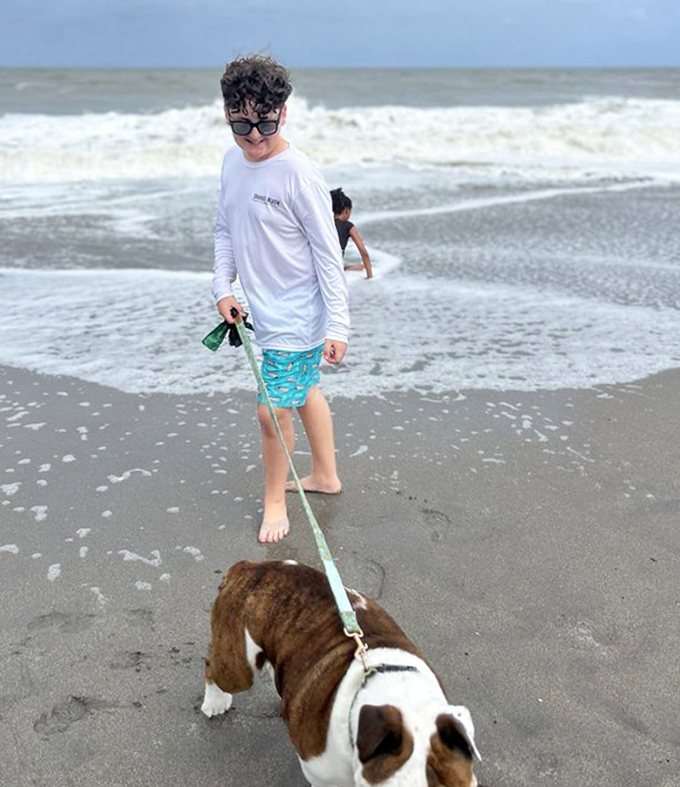 "Who's walking whom?" The age-old question answered at Jupiter Beach, where dogs lead the adventure while humans happily follow.
