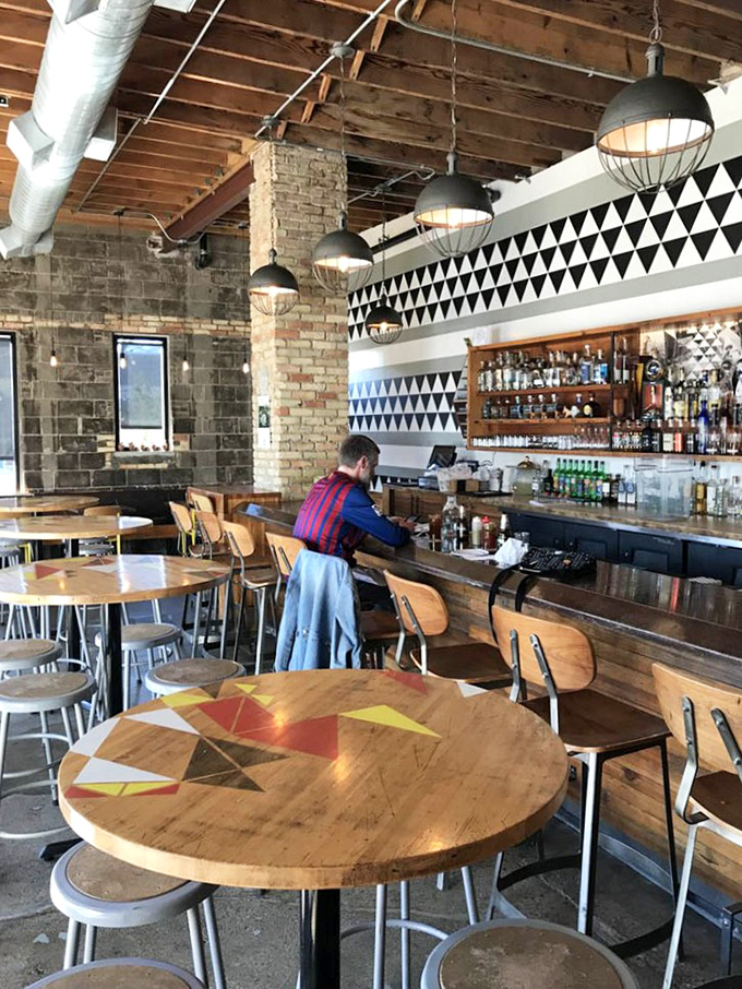 Industrial chic meets warm wood tones in this inviting interior where exposed brick and geometric patterns create the perfect backdrop for taco adventures.