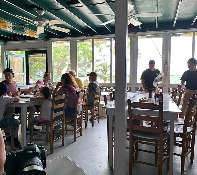 Rustic wooden tables await hungry patrons in this dining room where looking up reveals a ceiling blanketed with greenbacks from visitors worldwide.