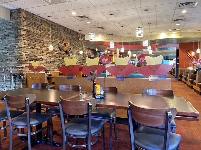 Stone walls meet cozy booths in this interior that whispers, "Stay awhile," as pendant lights cast a warm glow over hungry conversations.