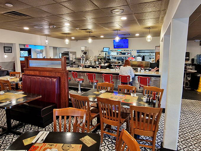 Classic red counter stools and patterned tile floors create that timeless diner atmosphere where comfort food and conversation flow freely.