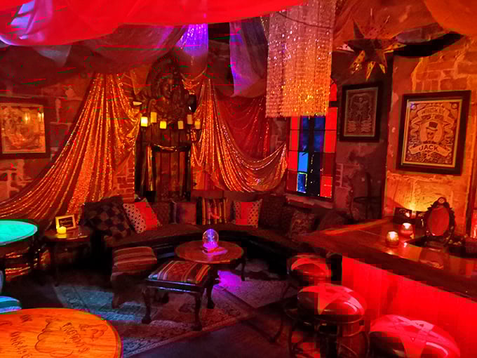 Plush velvet seating and dramatic drapery create an intimate sanctuary where whispered conversations happen beneath the glow of vintage chandeliers and candlelight.