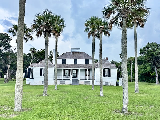 Sunlight bathes the historic main house, its white clapboard exterior a striking contrast against Florida's lush landscape.