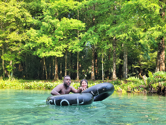 Floating buddies share a moment of pure joy on the spring's gentle current. Nothing says "Florida vacation" quite like drifting through paradise on a black inner tube.