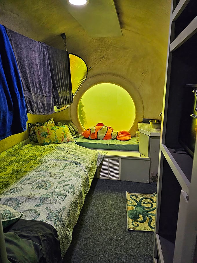 Cozy underwater accommodations featuring a glowing porthole window &ndash; like sleeping in a submarine designed by someone with a flair for marine-themed decor.
