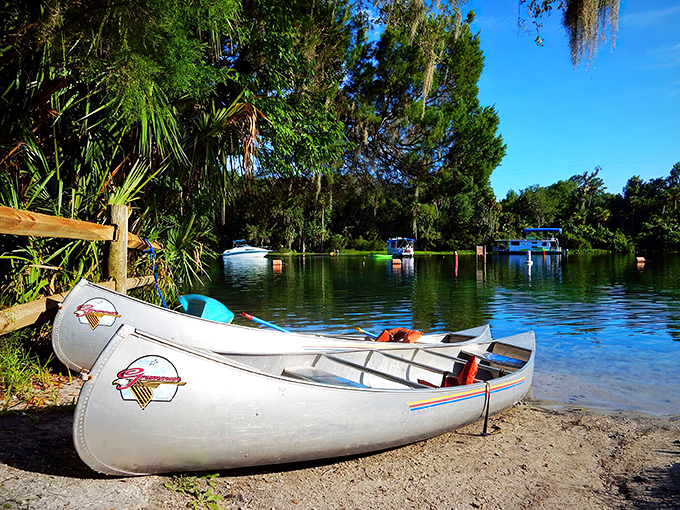 White canoes rest on shore, patiently waiting for their next adventure across waters so clear they seem almost invisible.