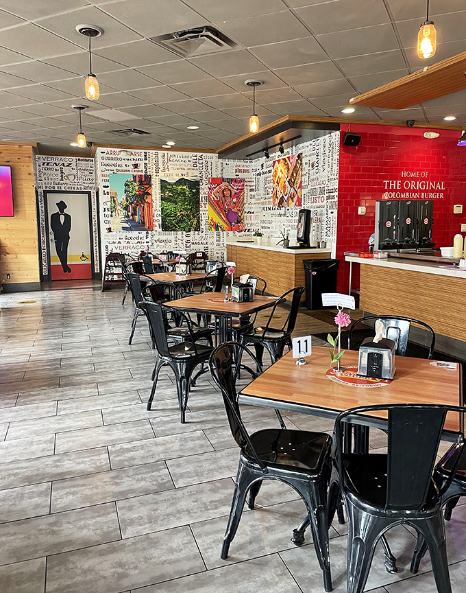 Modern meets Colombian comfort inside with wood accents, pendant lighting, and that bold red wall proudly declaring its burger heritage.