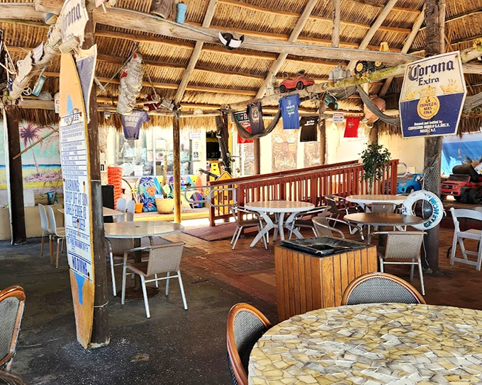 The thatched-roof interior blends tiki bar charm with Florida casual, where surfboards and t-shirts hang from rafters like treasures from shipwrecks past.